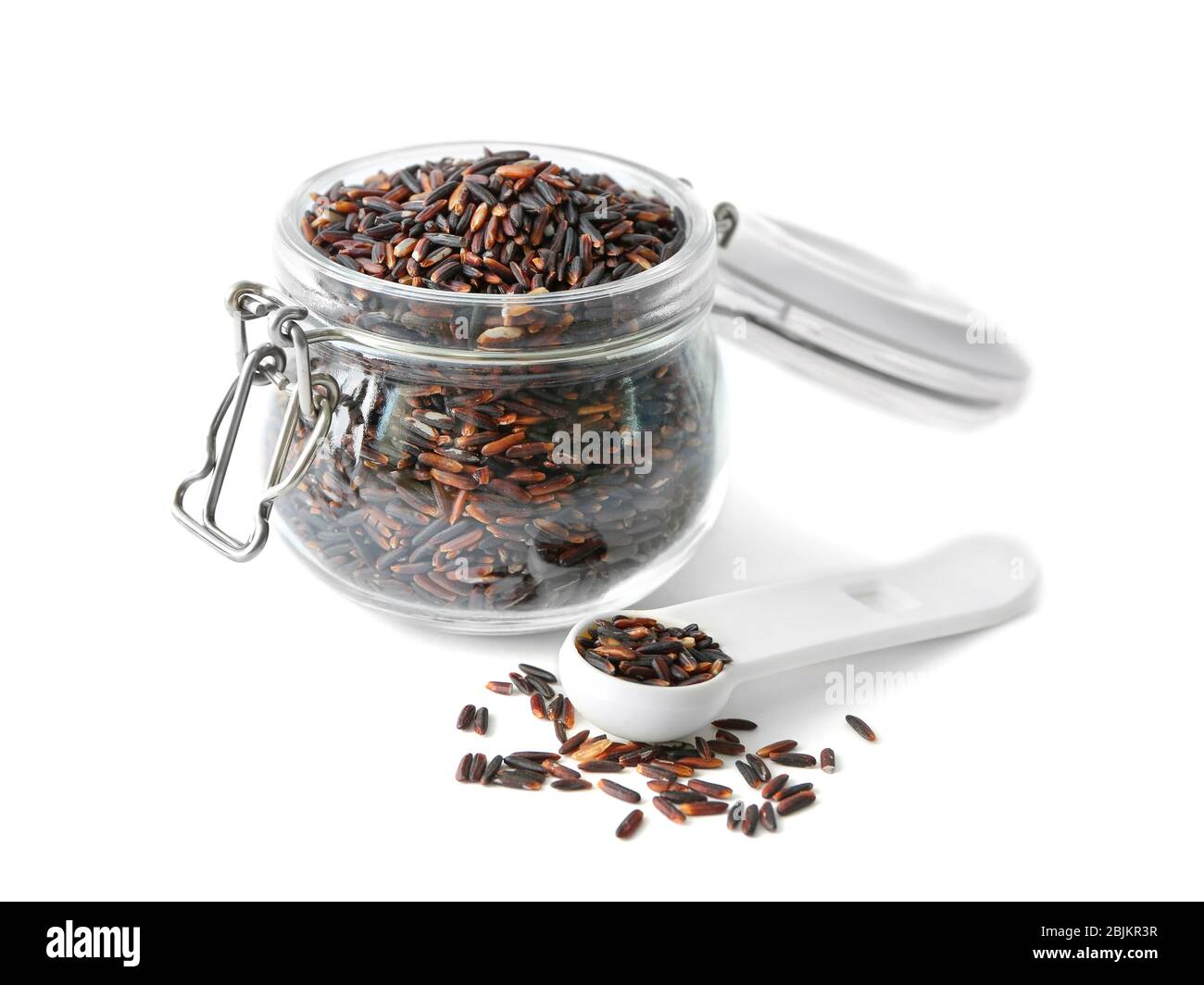 Glass jar with brown rice on white background Stock Photo - Alamy