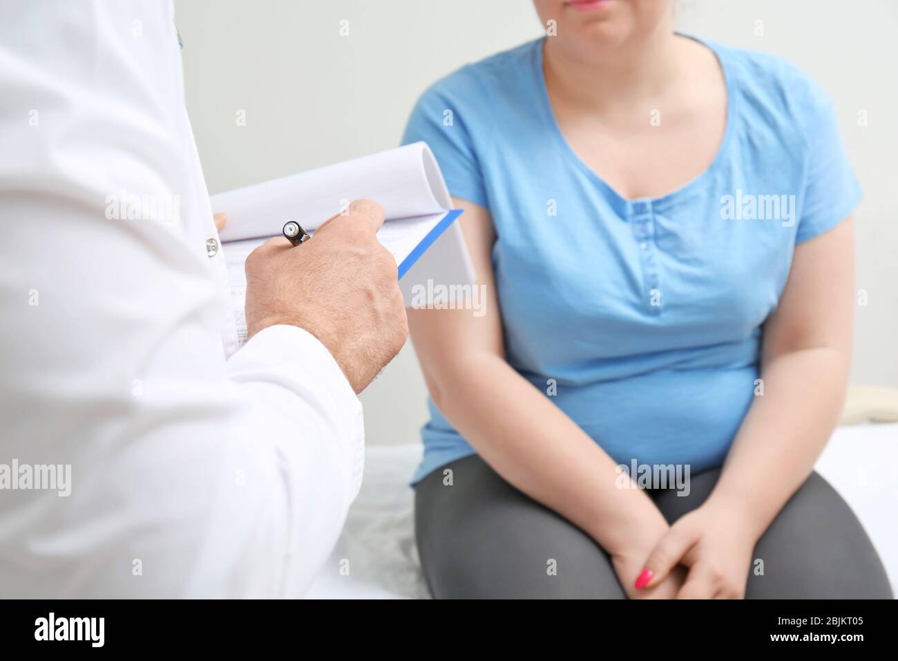 Overweight woman discussing test results with doctor in hospital Stock ...