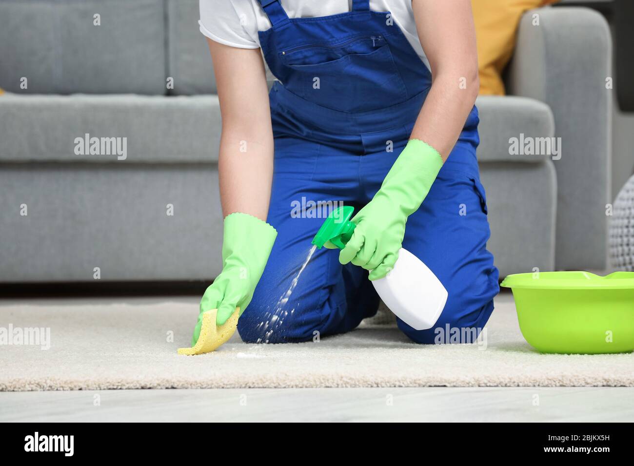 Man cleaning carpet in living room Stock Photo - Alamy