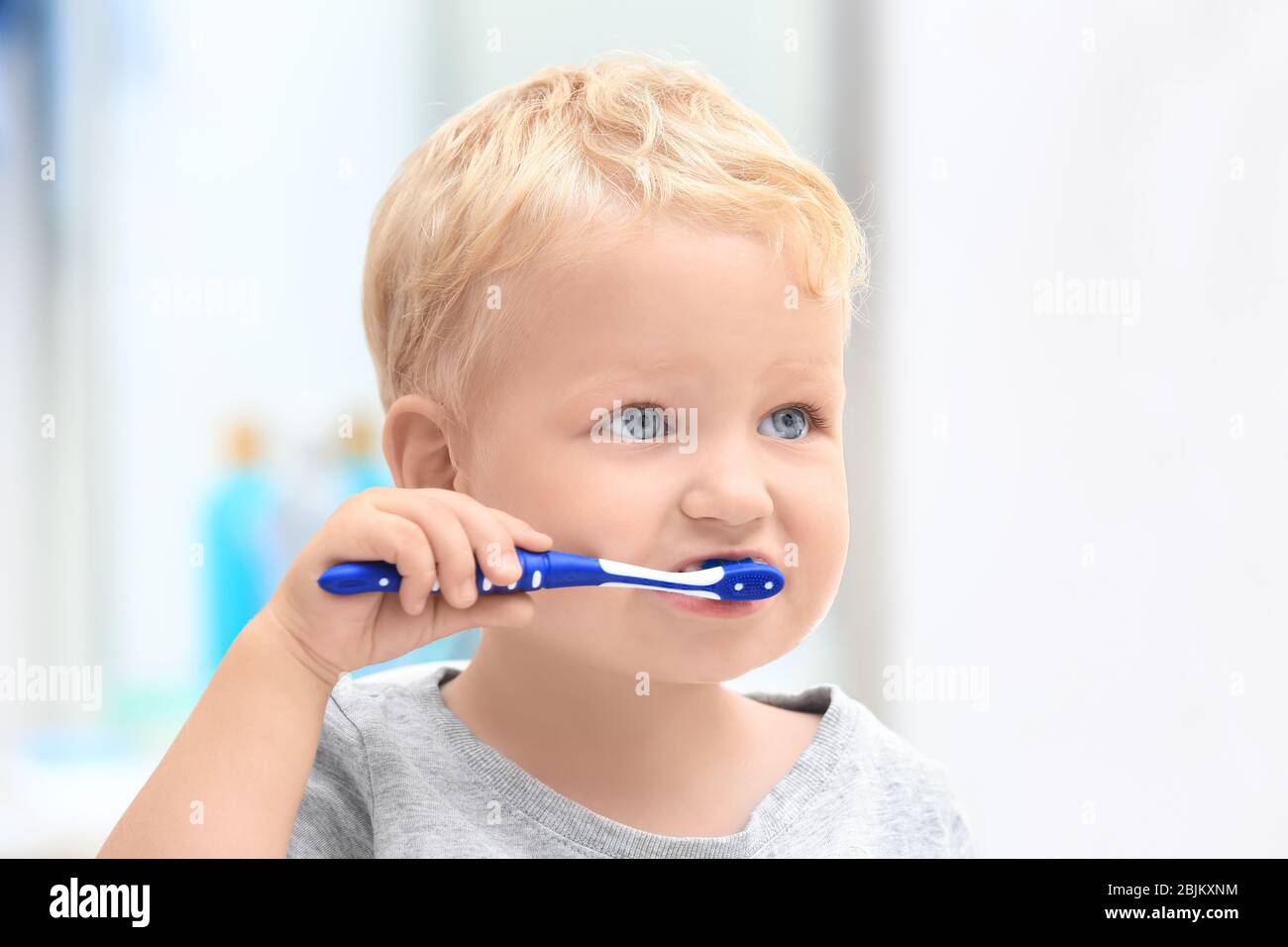 Cute little child cleaning teeth in bathroom Stock Photo - Alamy