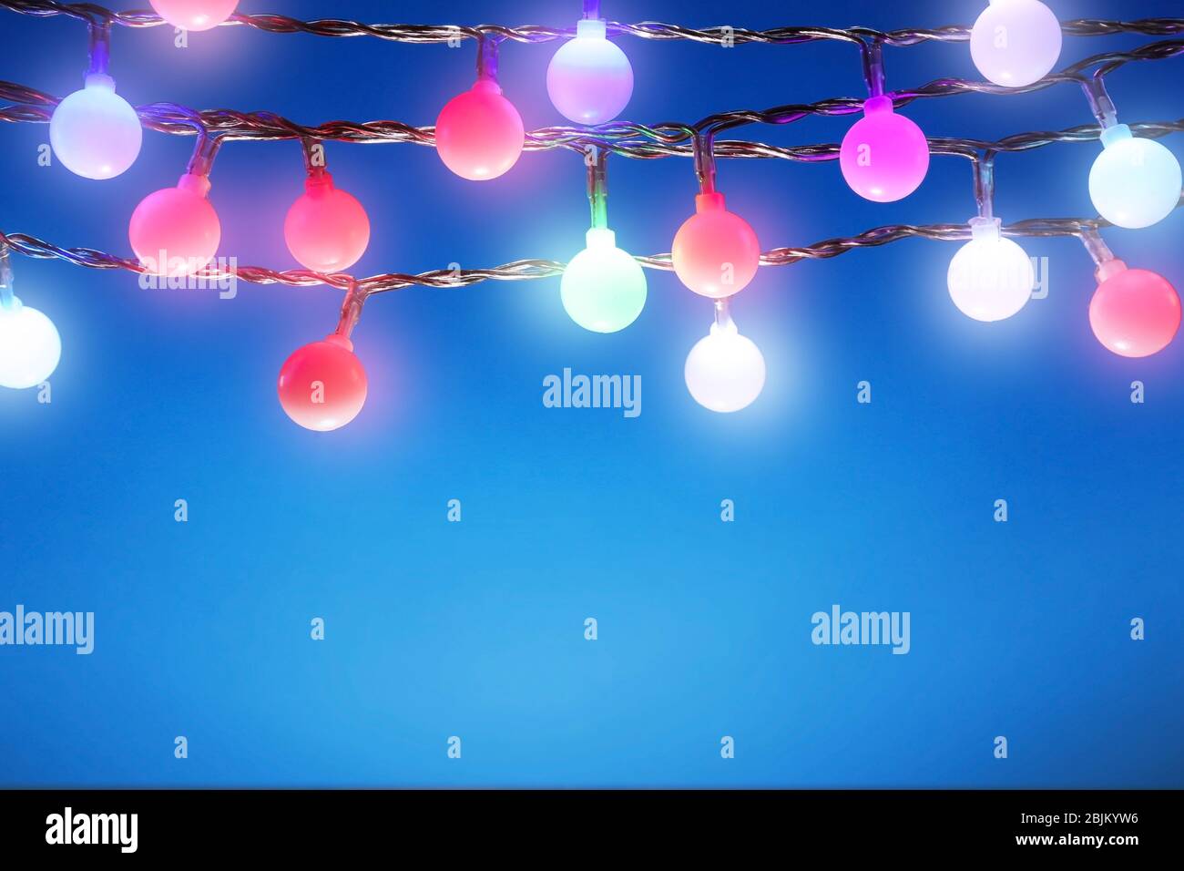 Christmas lights on color background Stock Photo - Alamy