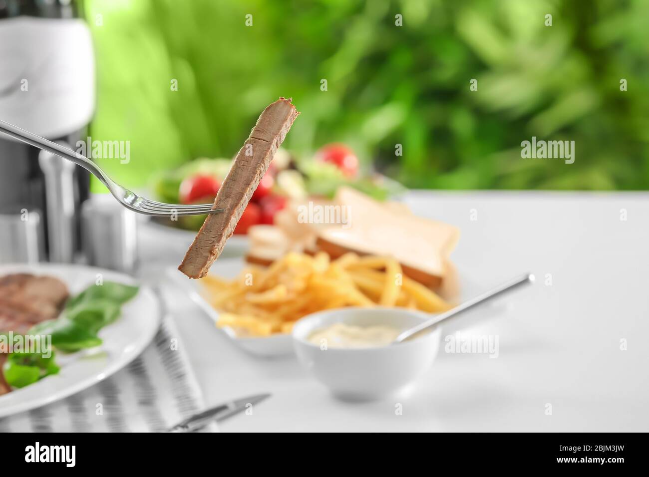 Fork with piece of delicious grilled steak in restaurant Stock Photo ...