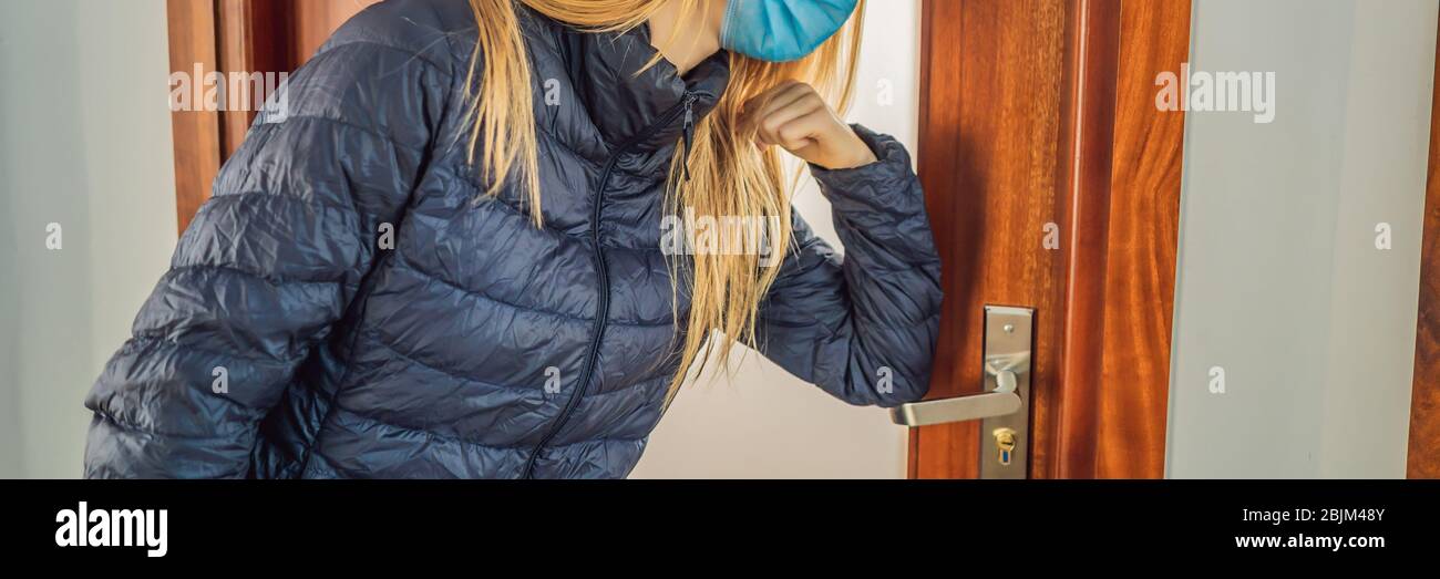 Woman wearing mask opening the door with the elbow for protection ...