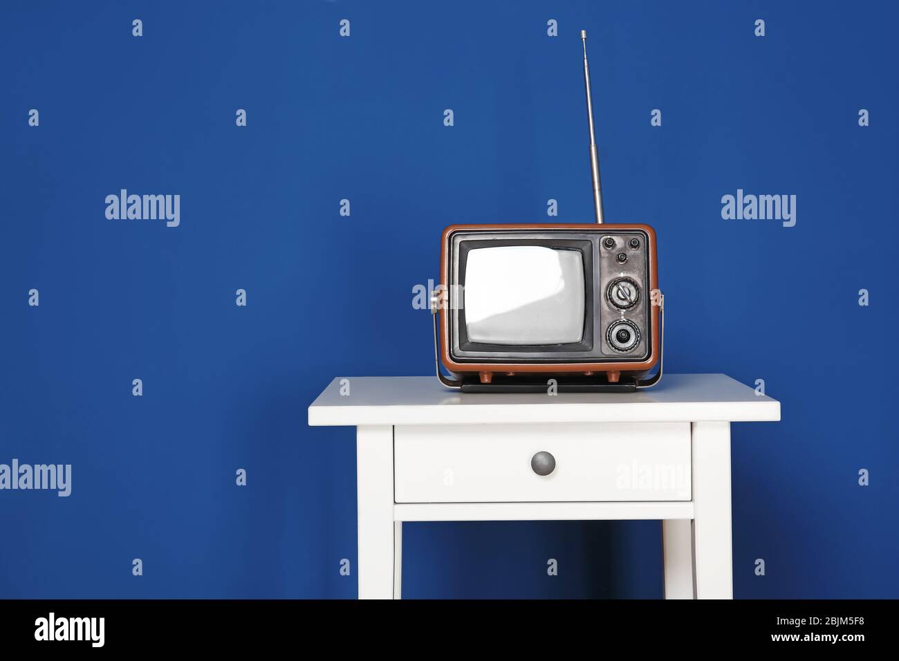 Little old TV on table against color wall Stock Photo - Alamy