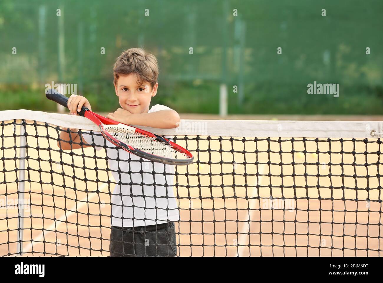 Cute little boy with tennis racket on court Stock Photo - Alamy
