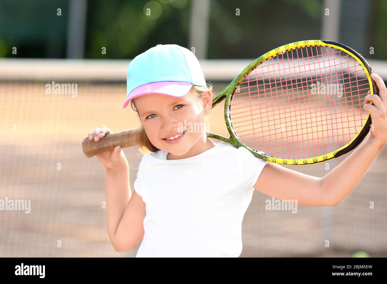 Cute little girl with tennis racket on court Stock Photo - Alamy