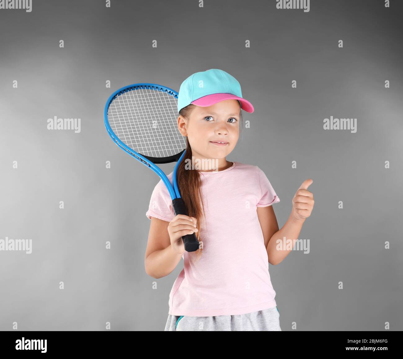 Cute little girl with tennis racket on color background Stock Photo - Alamy