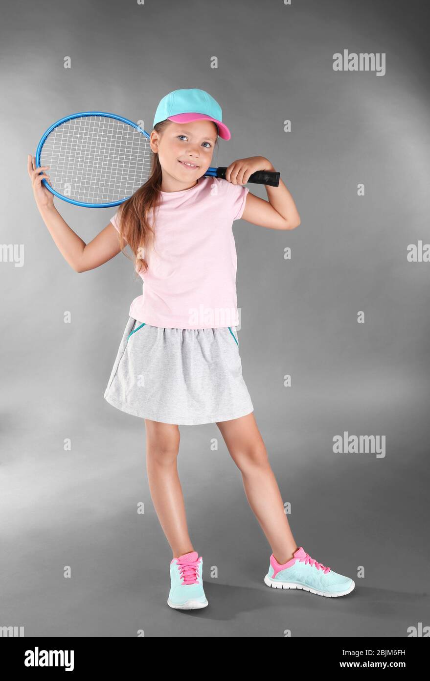 Cute little girl with tennis racket on color background Stock Photo - Alamy