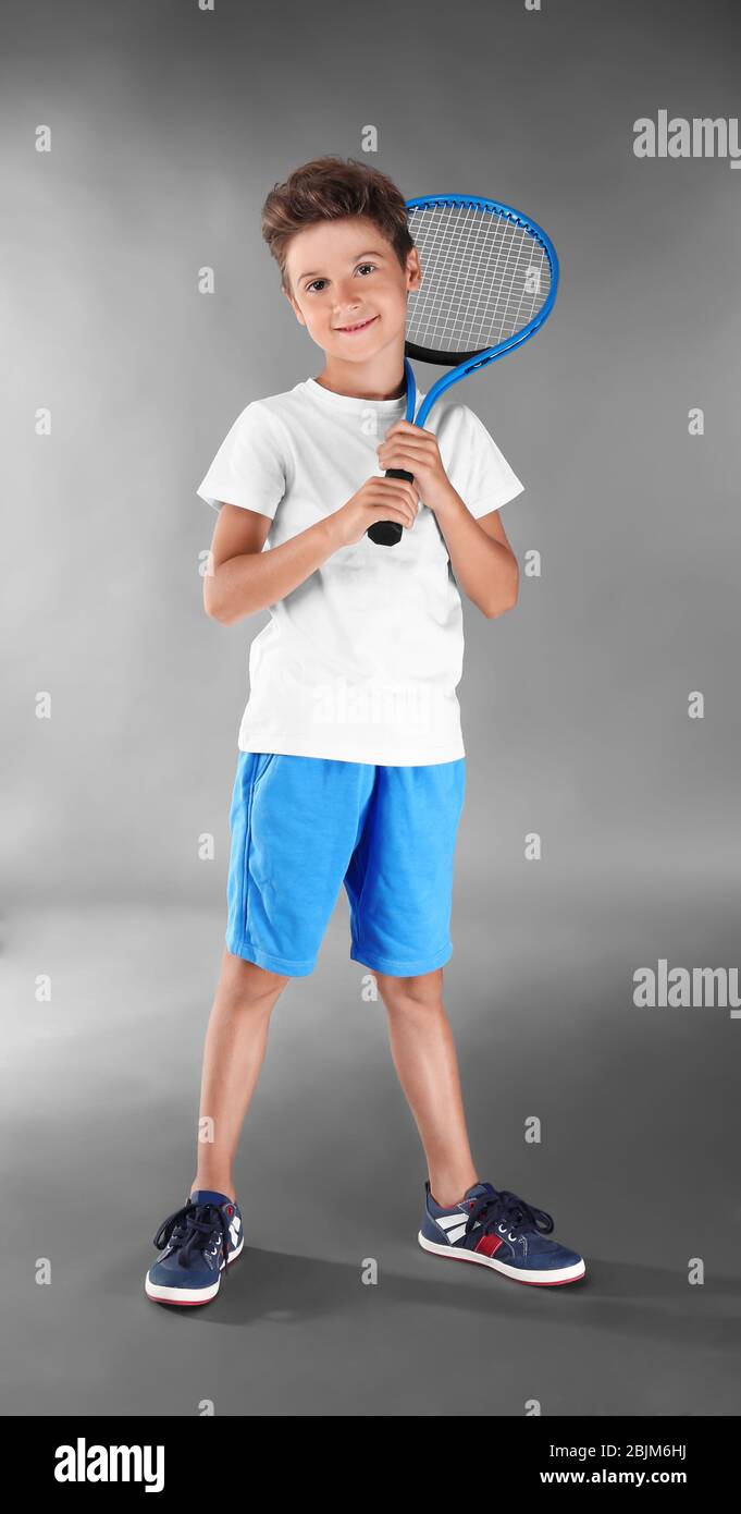 Cute little boy with tennis racket on color background Stock Photo - Alamy