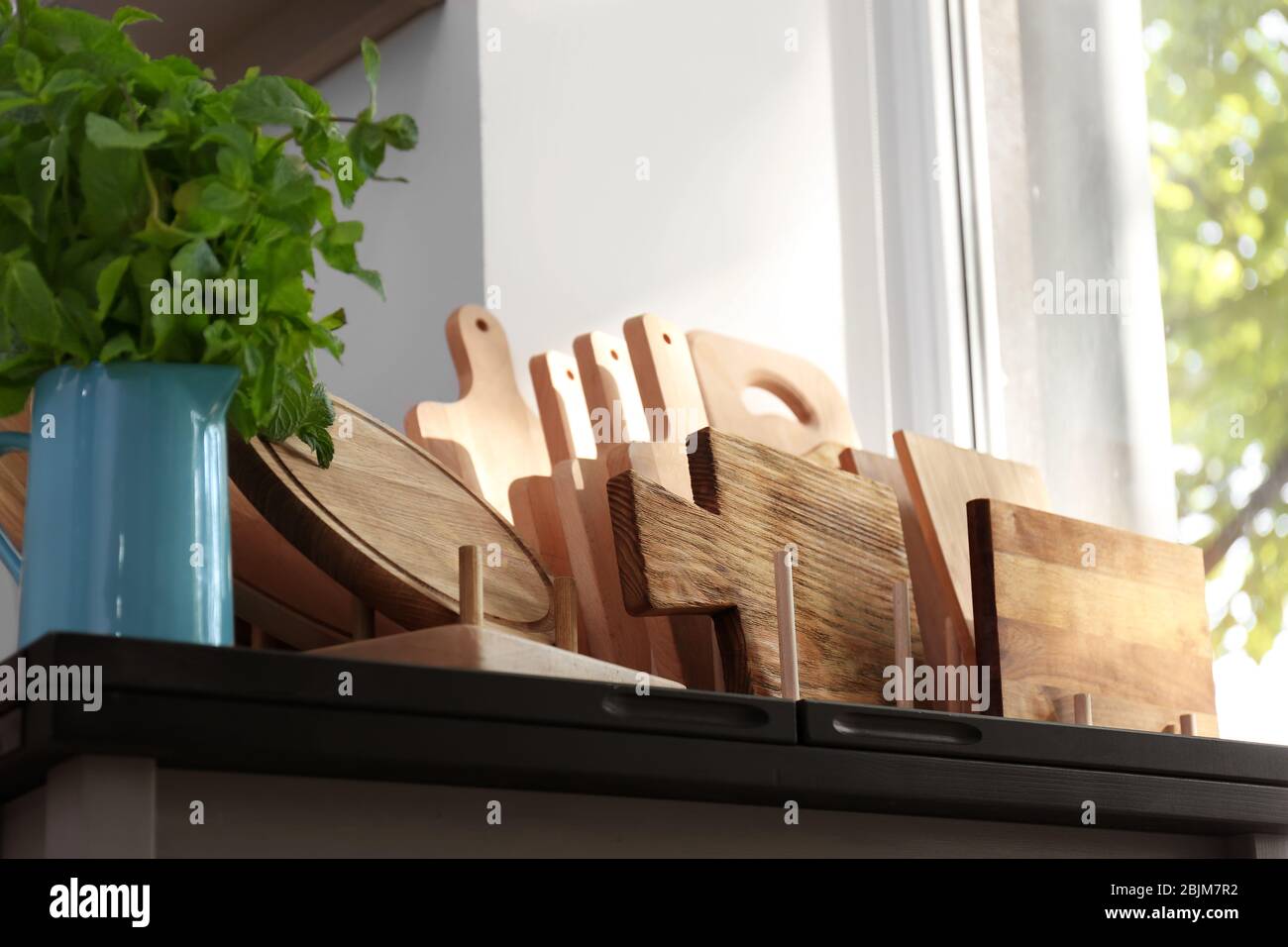 Different wooden boards on table near window in kitchen Stock Photo - Alamy