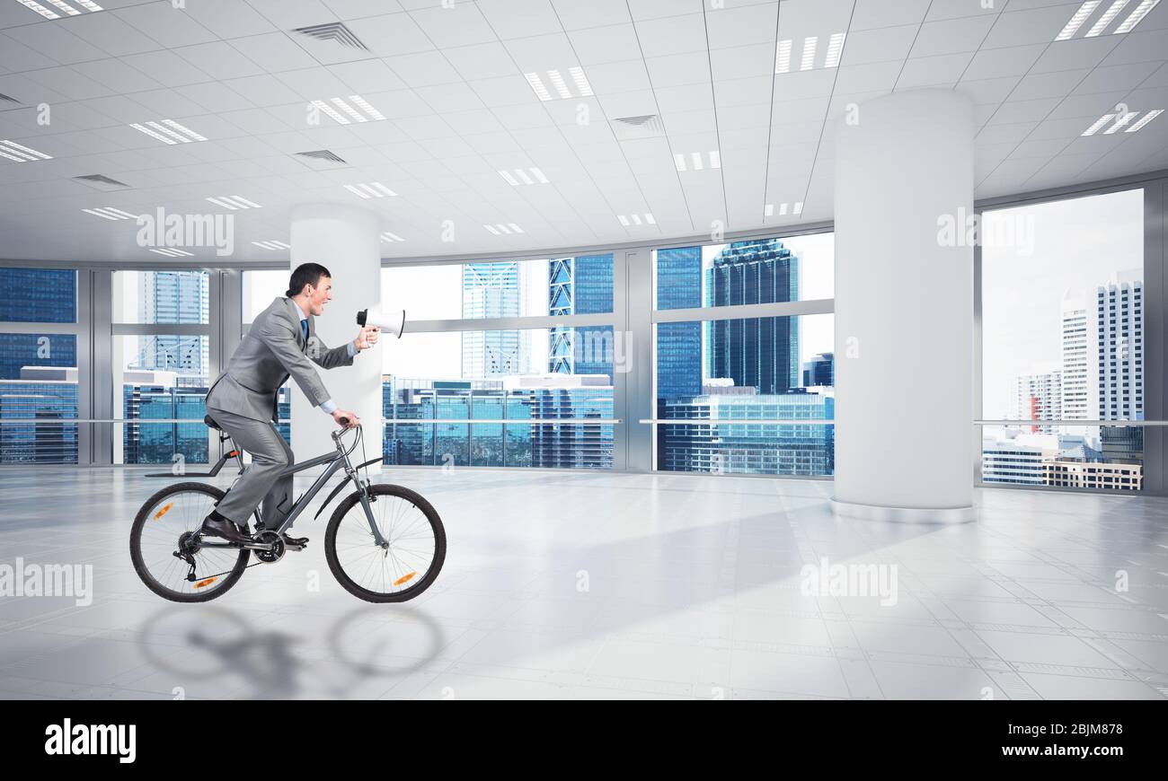 Manager riding bicycle at conference hall Stock Photo - Alamy