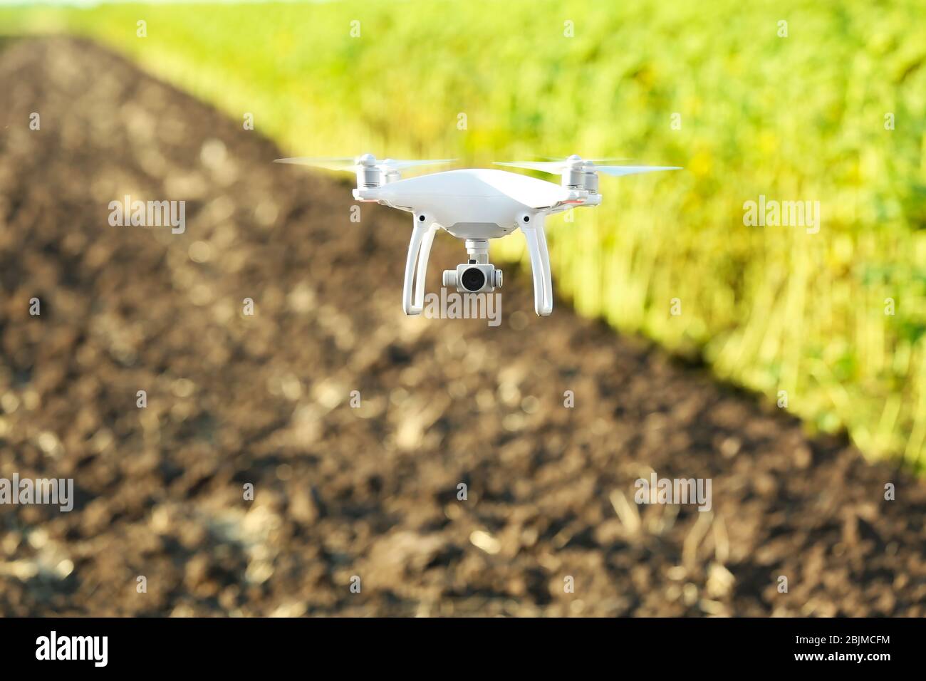 Modern quadcopter flying over field Stock Photo - Alamy