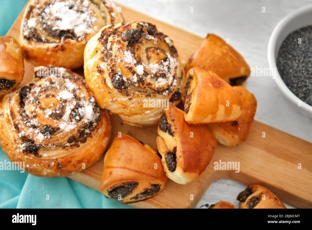 Tasty pastries with poppy seeds on wooden board Stock Photo - Alamy