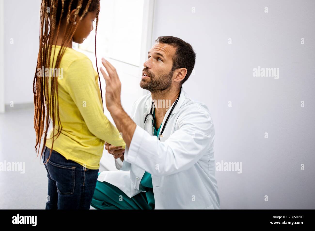 Doctor comforting, supporting a worried sad girl kid in hospital Stock ...