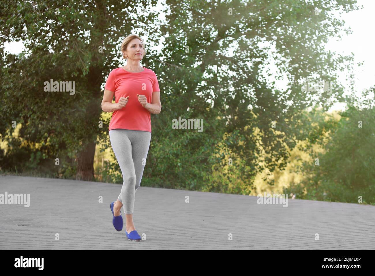 Beautiful mature woman running outdoors Stock Photo - Alamy