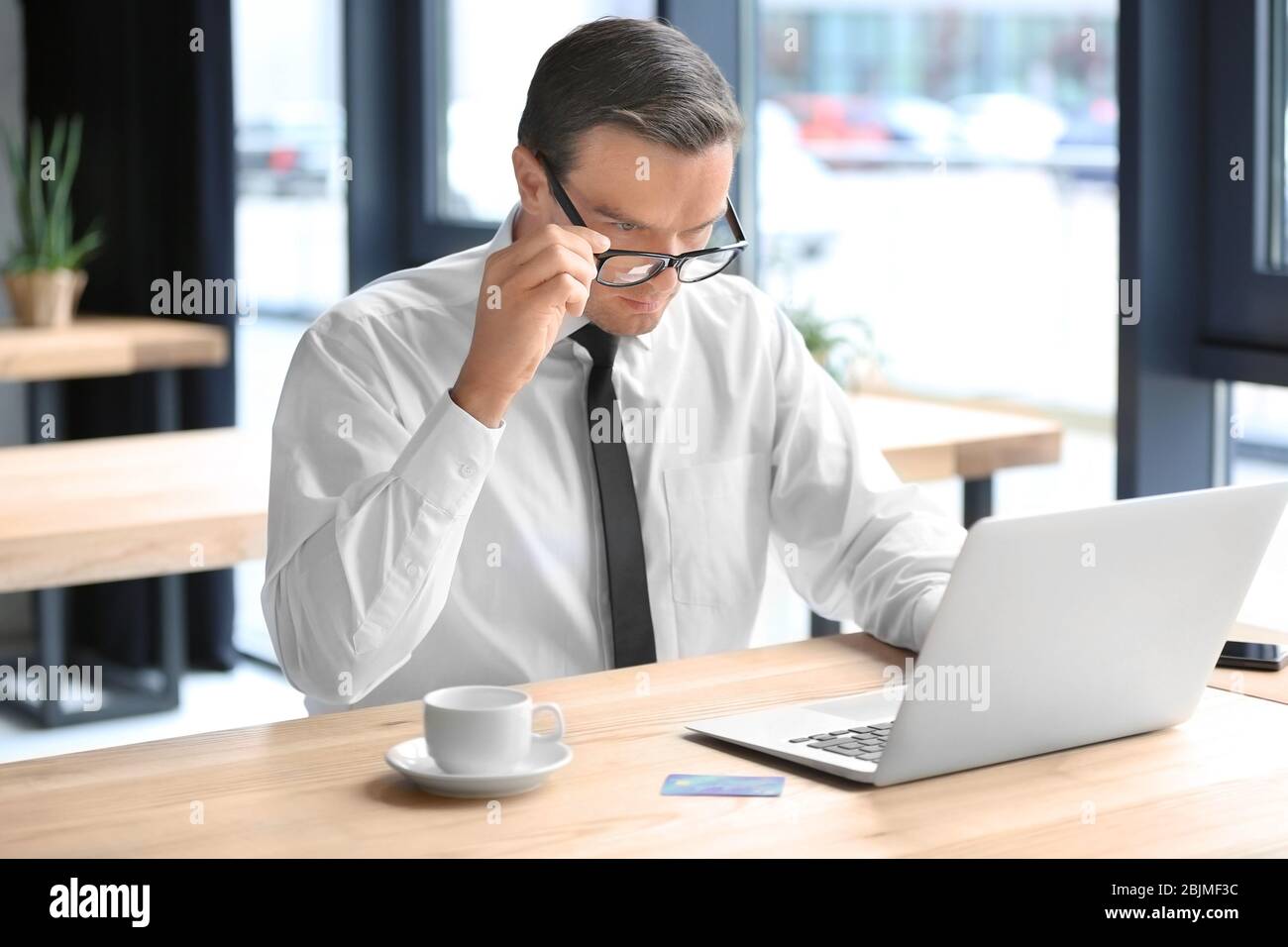 Young businessman using laptop at workplace Stock Photo - Alamy