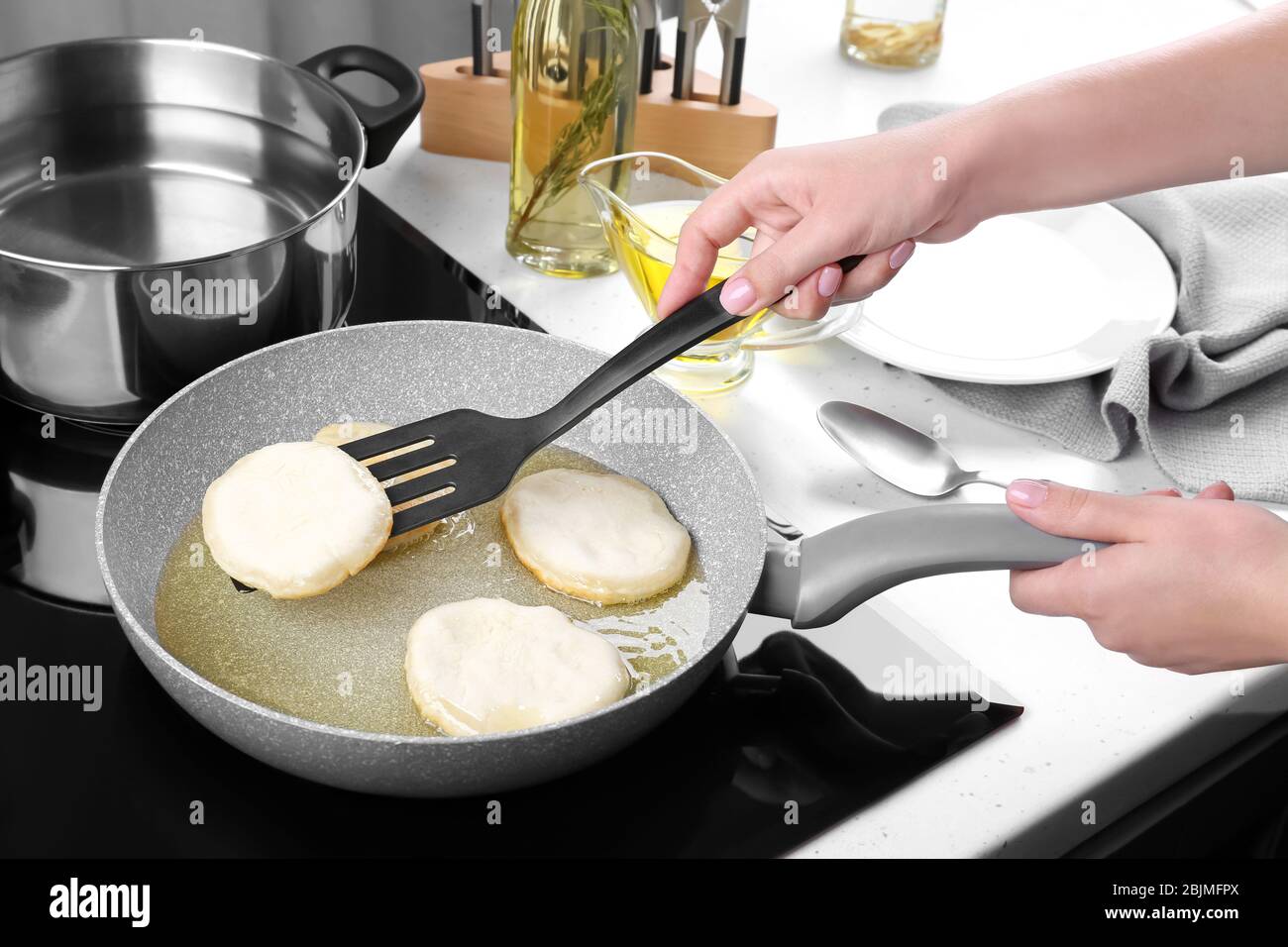 Woman frying pancakes in kitchen Stock Photo - Alamy