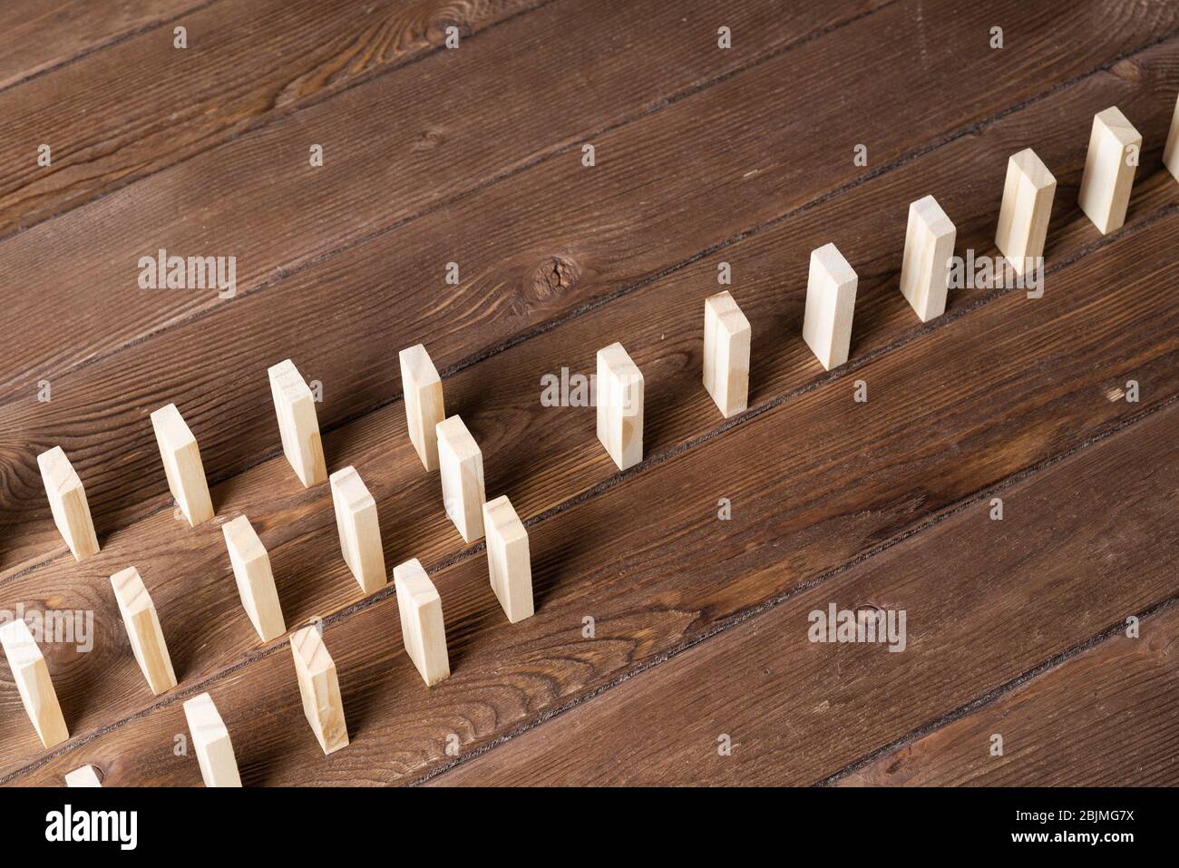 Rows of dominoes standing on wooden table Stock Photo - Alamy