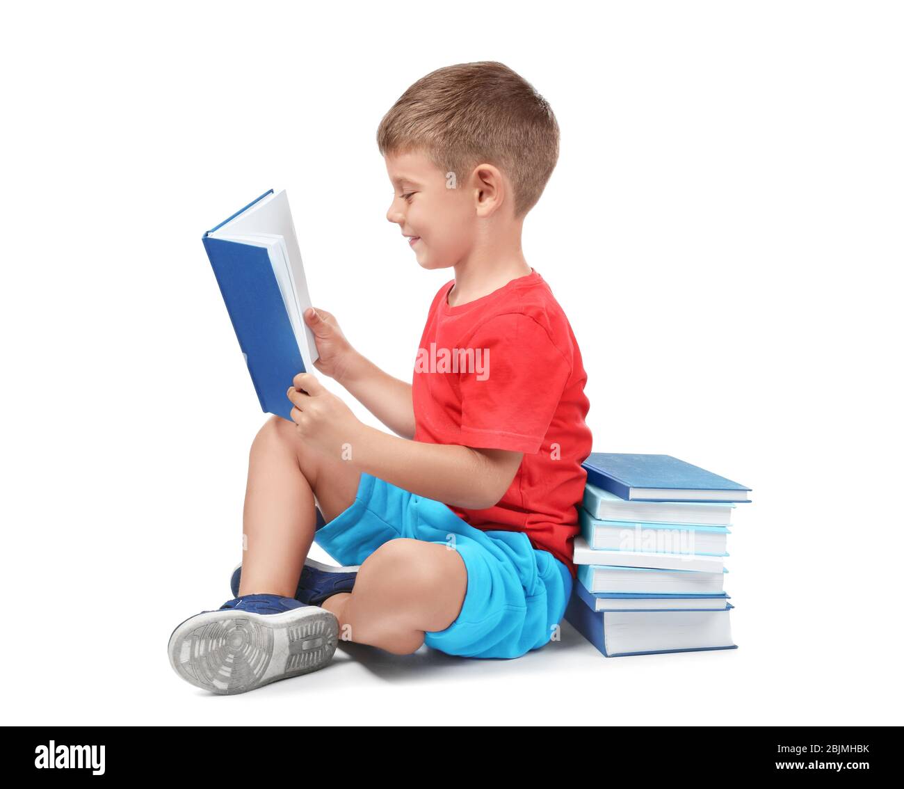 Cute little boy reading books on white background Stock Photo - Alamy