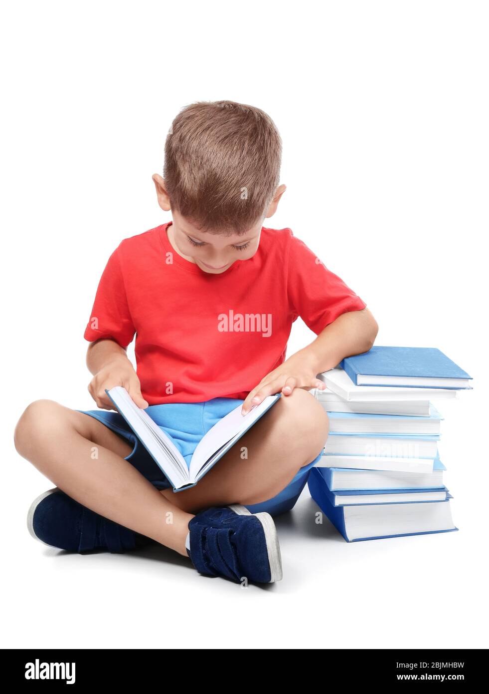 Cute little boy reading books on white background Stock Photo - Alamy