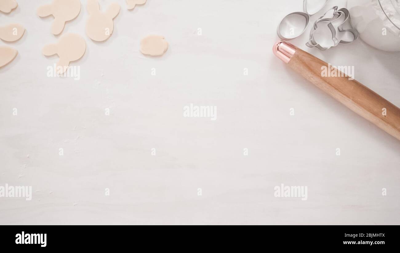 Step by step. Flat lay. Cutting sugar cookie dough with Easter shaped ...