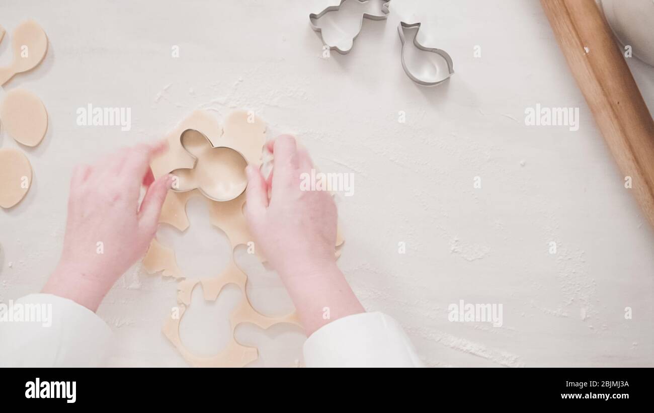 Step by step. Flat lay. Cutting sugar cookie dough with Easter shaped ...