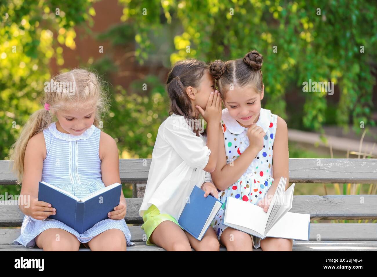 Cute little children reading books in park Stock Photo - Alamy