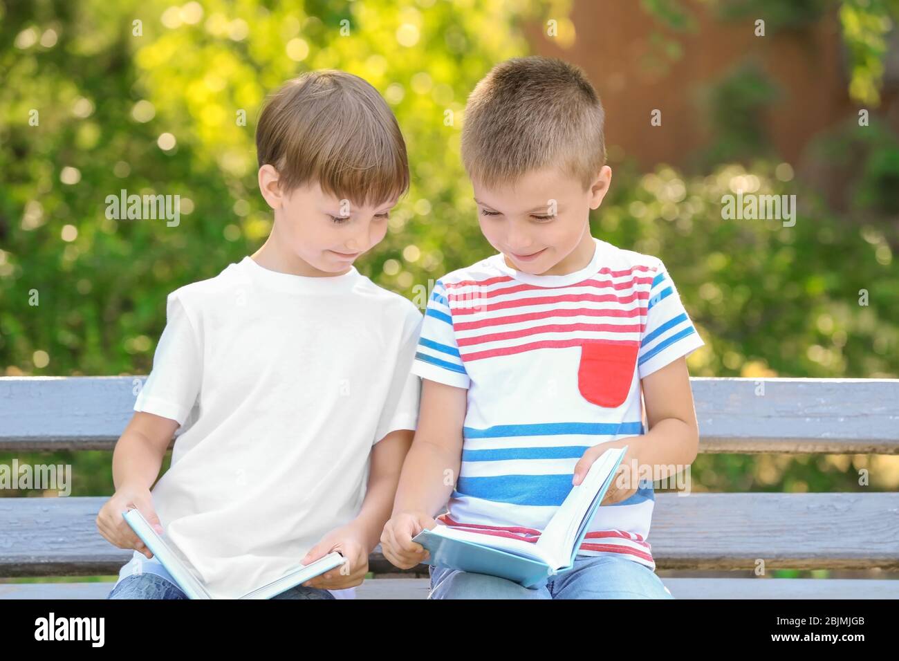 Cute little children reading books in park Stock Photo - Alamy