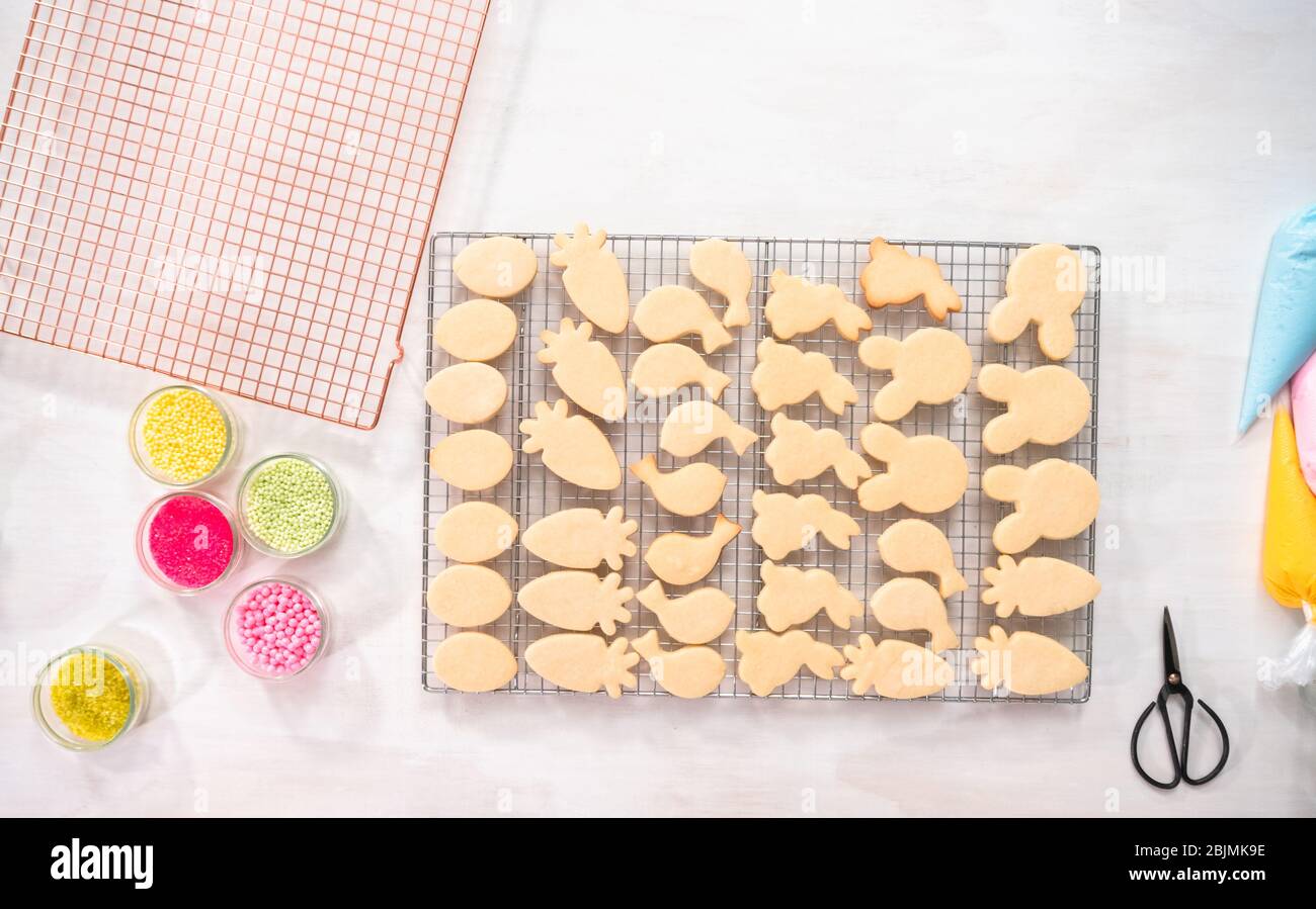 Flat lay. Decorating Easter sugar cookies with rotal icing Stock Photo ...