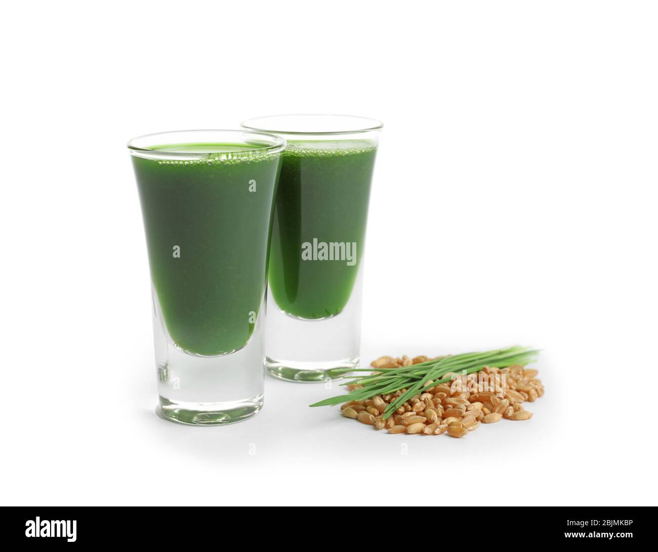 Wheat grass shots and grain on white background Stock Photo - Alamy