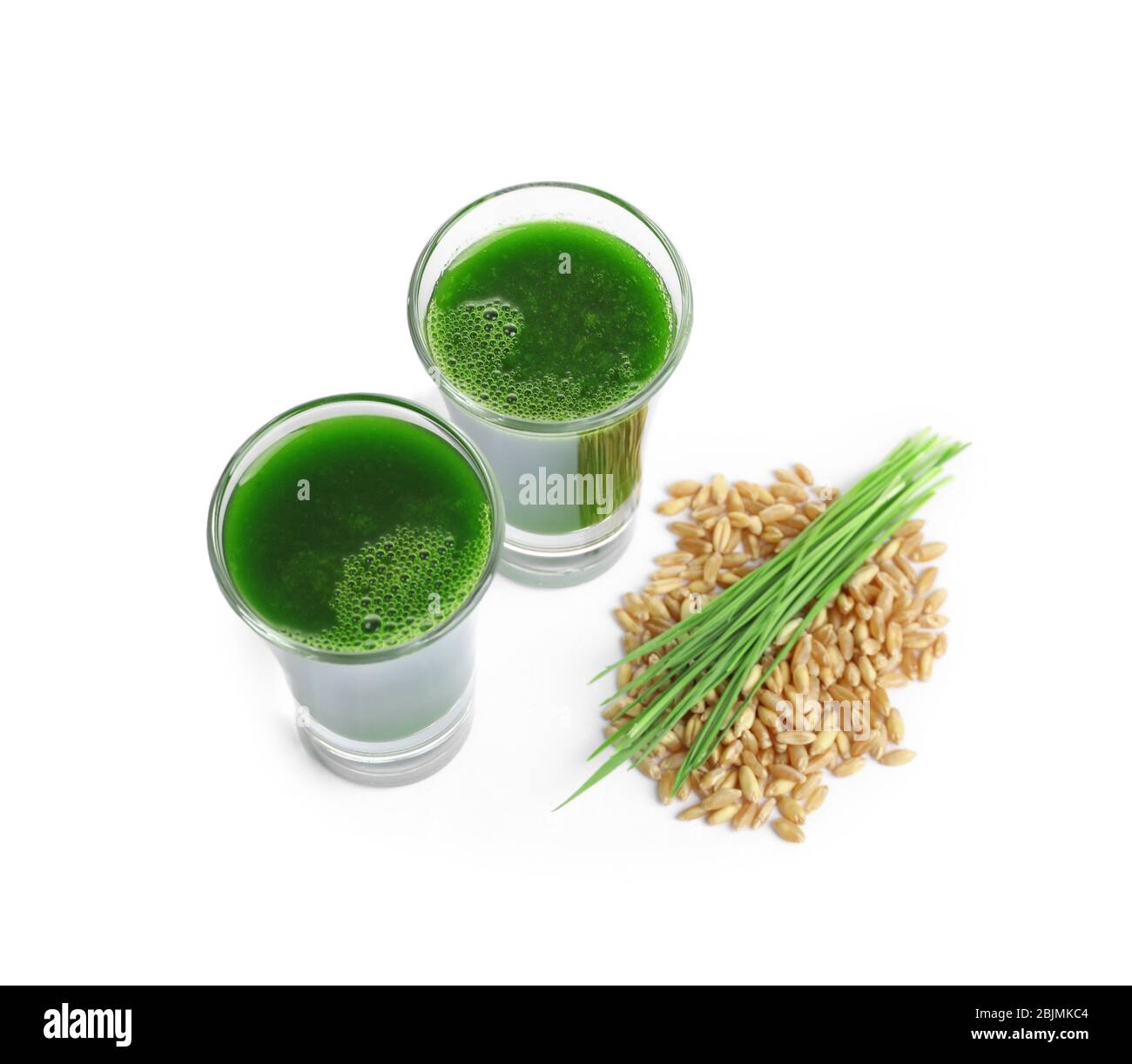 Wheat grass shots and grain on white background Stock Photo - Alamy