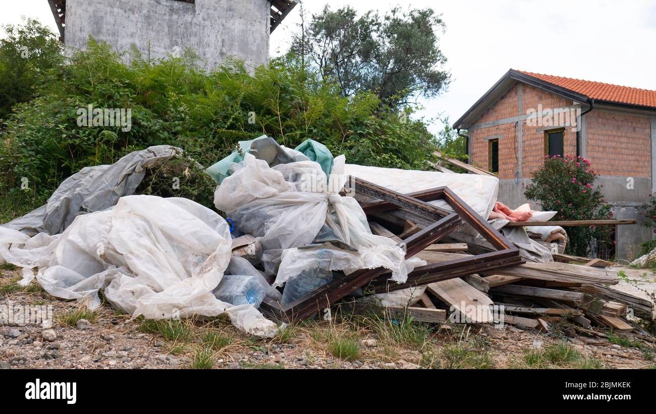 Garbage dumped next to abandoned houses Stock Photo - Alamy