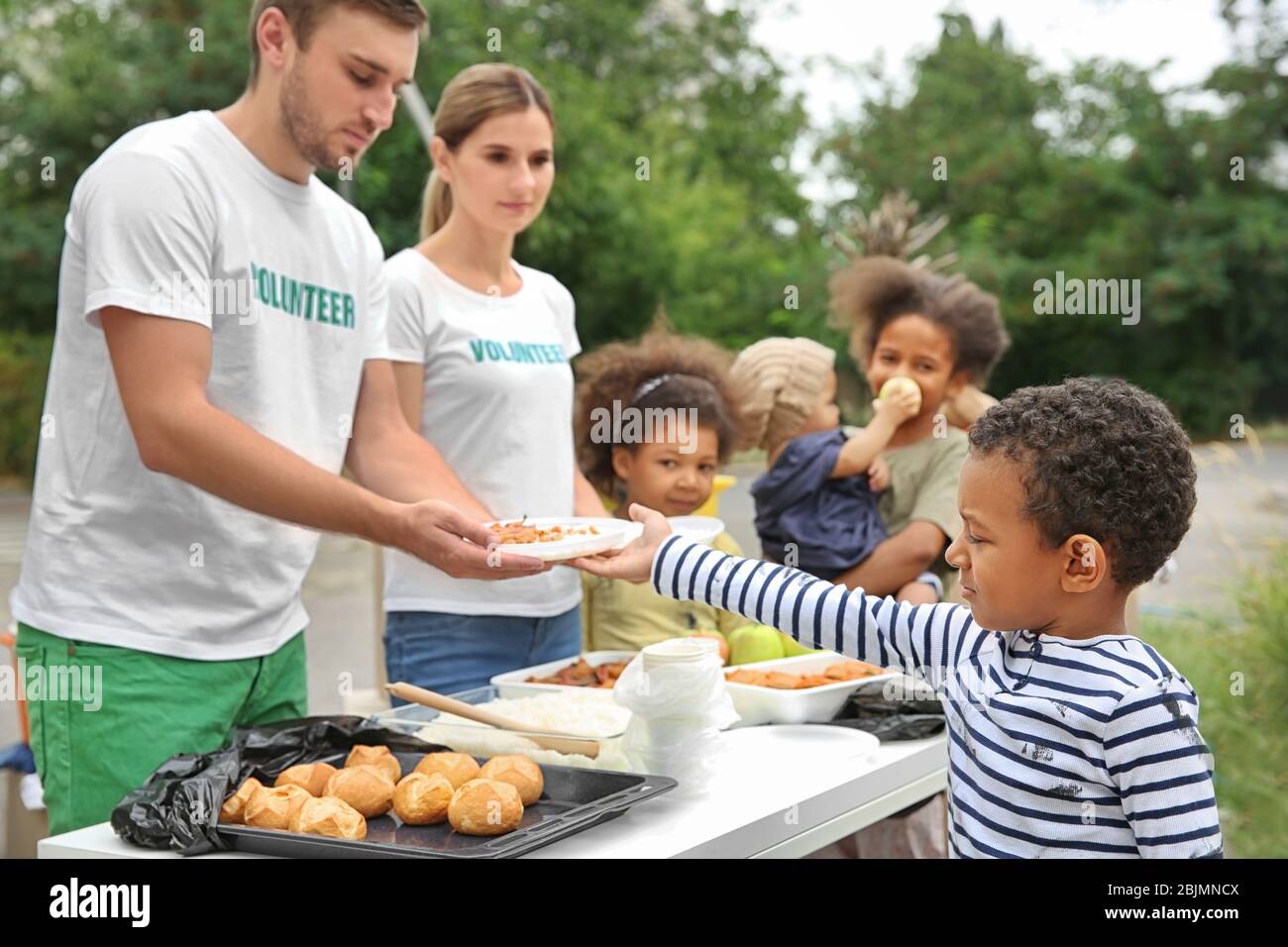 Volunteers sharing food with poor African children outdoors Stock Photo ...