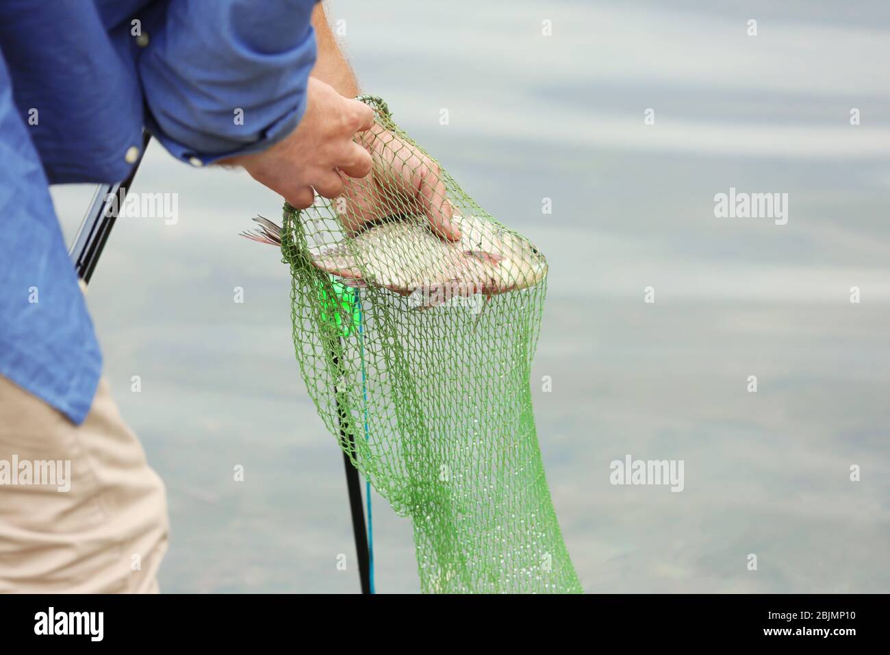 Man taking fish out water hi-res stock photography and images - Alamy