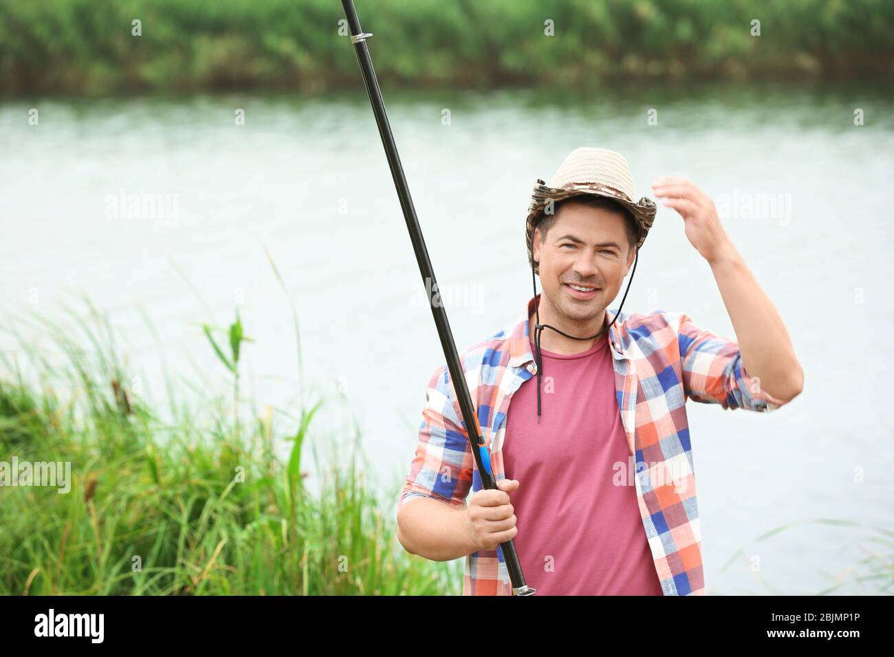 Young man fishing riverside hi-res stock photography and images - Alamy