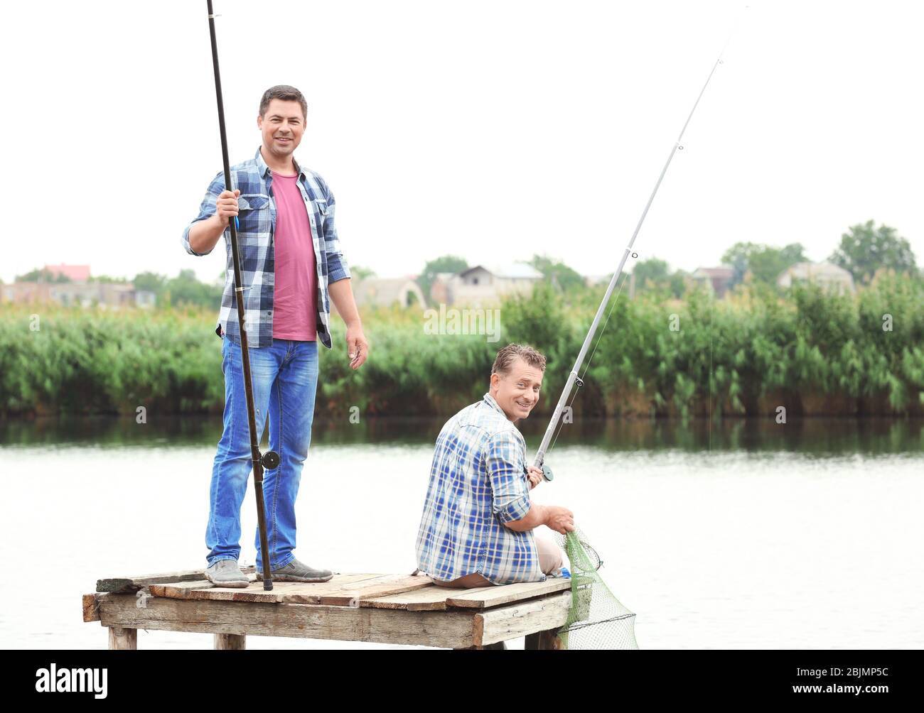 Man holding fishing net rod hi-res stock photography and images - Alamy