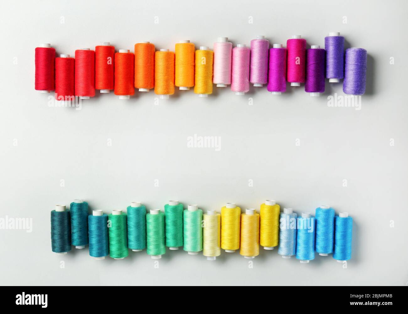 Many colorful threads on white background Stock Photo - Alamy