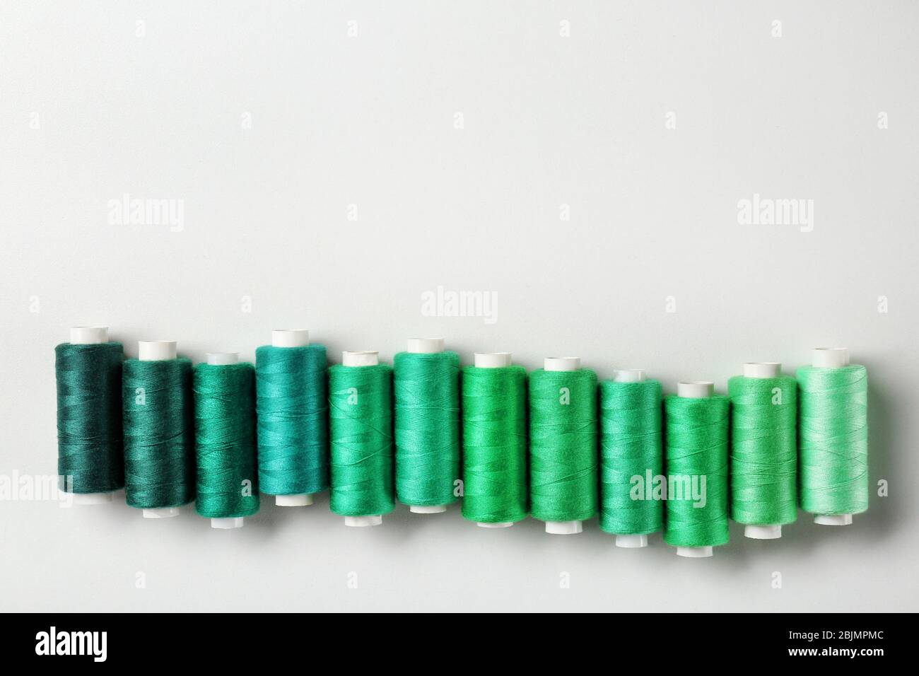 Green threads of different shades on white background Stock Photo - Alamy