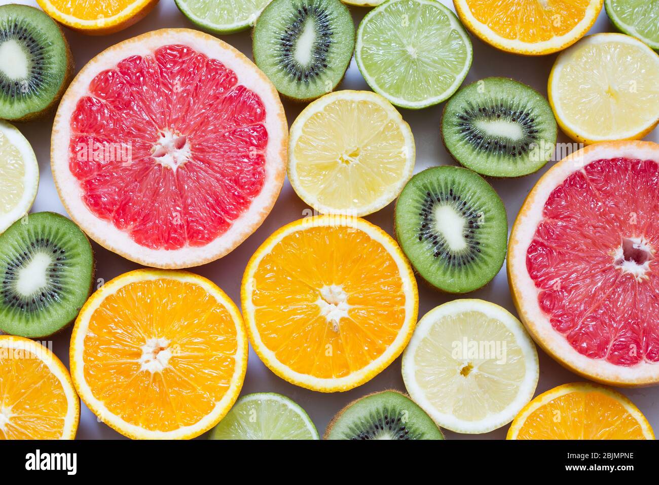 Flat lay top view of colorful variety of fresh citrus fruits half cut ...