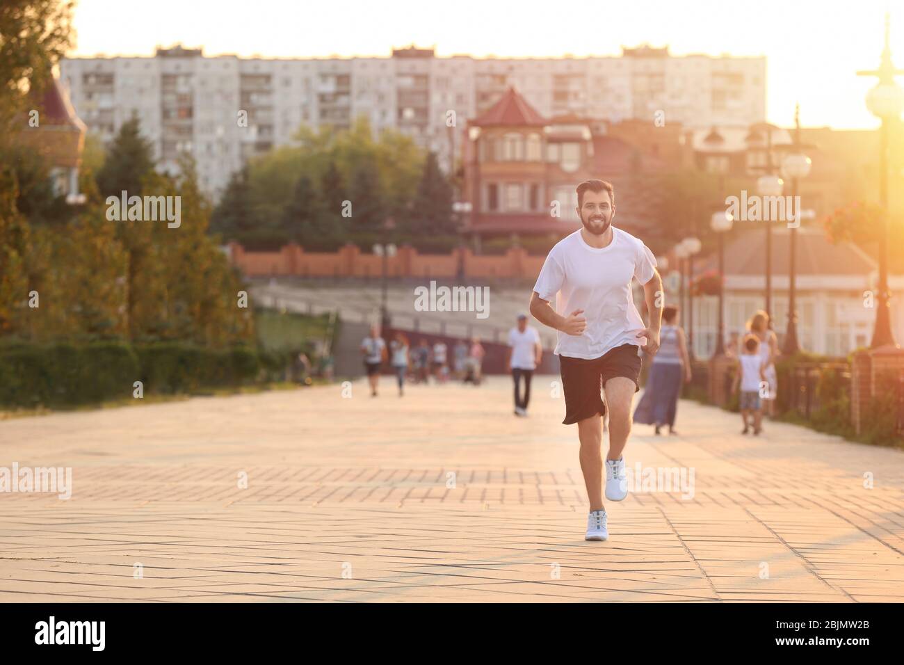 Handsome young man running on street Stock Photo - Alamy