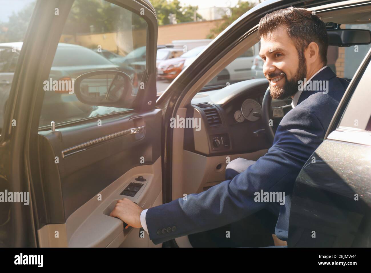Handsome man in suit getting out of car Stock Photo - Alamy