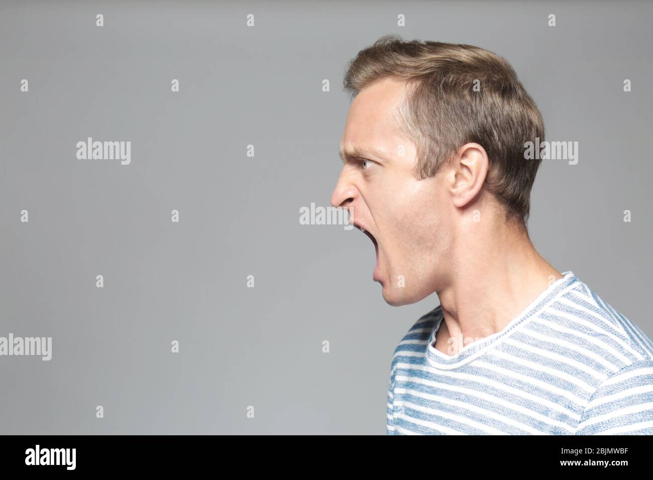 Emotional man on grey background Stock Photo - Alamy