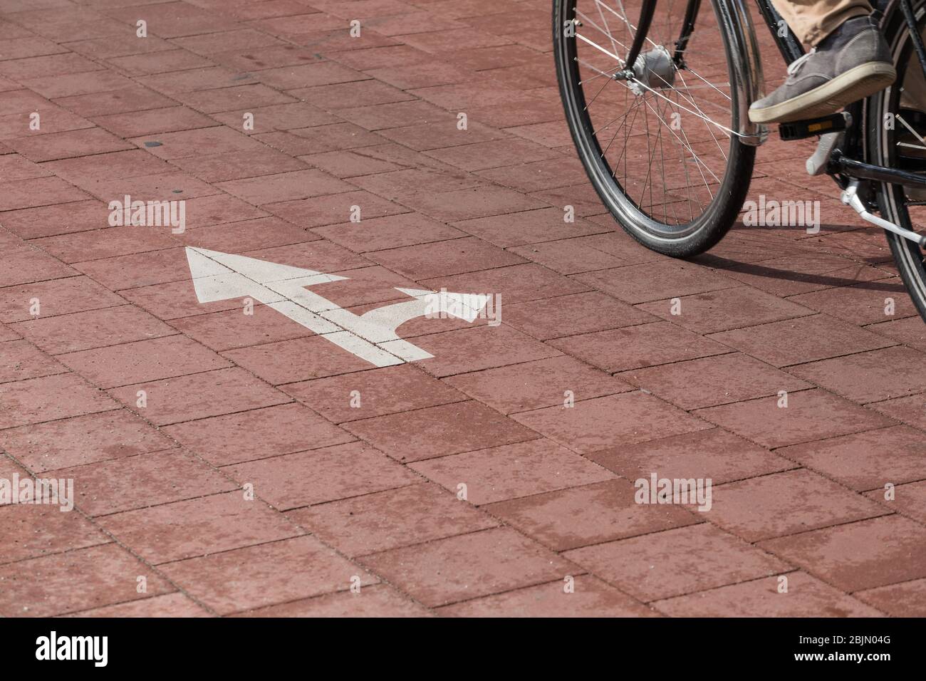 bike on red cycle lane with arrow Stock Photo - Alamy