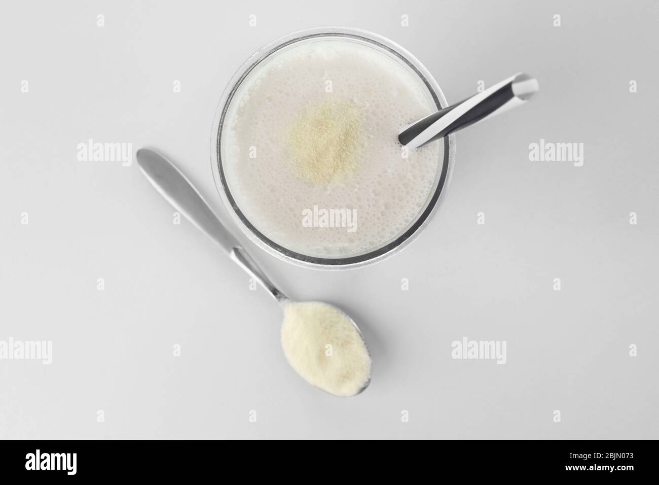 Glass with protein shake and powder in spoon on white background Stock ...