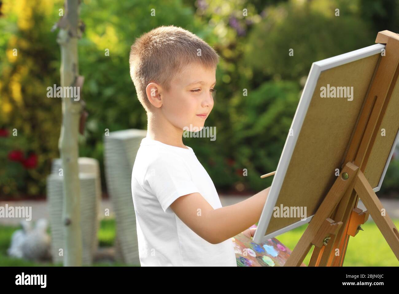 Cute little boy painting picture, outdoors Stock Photo - Alamy