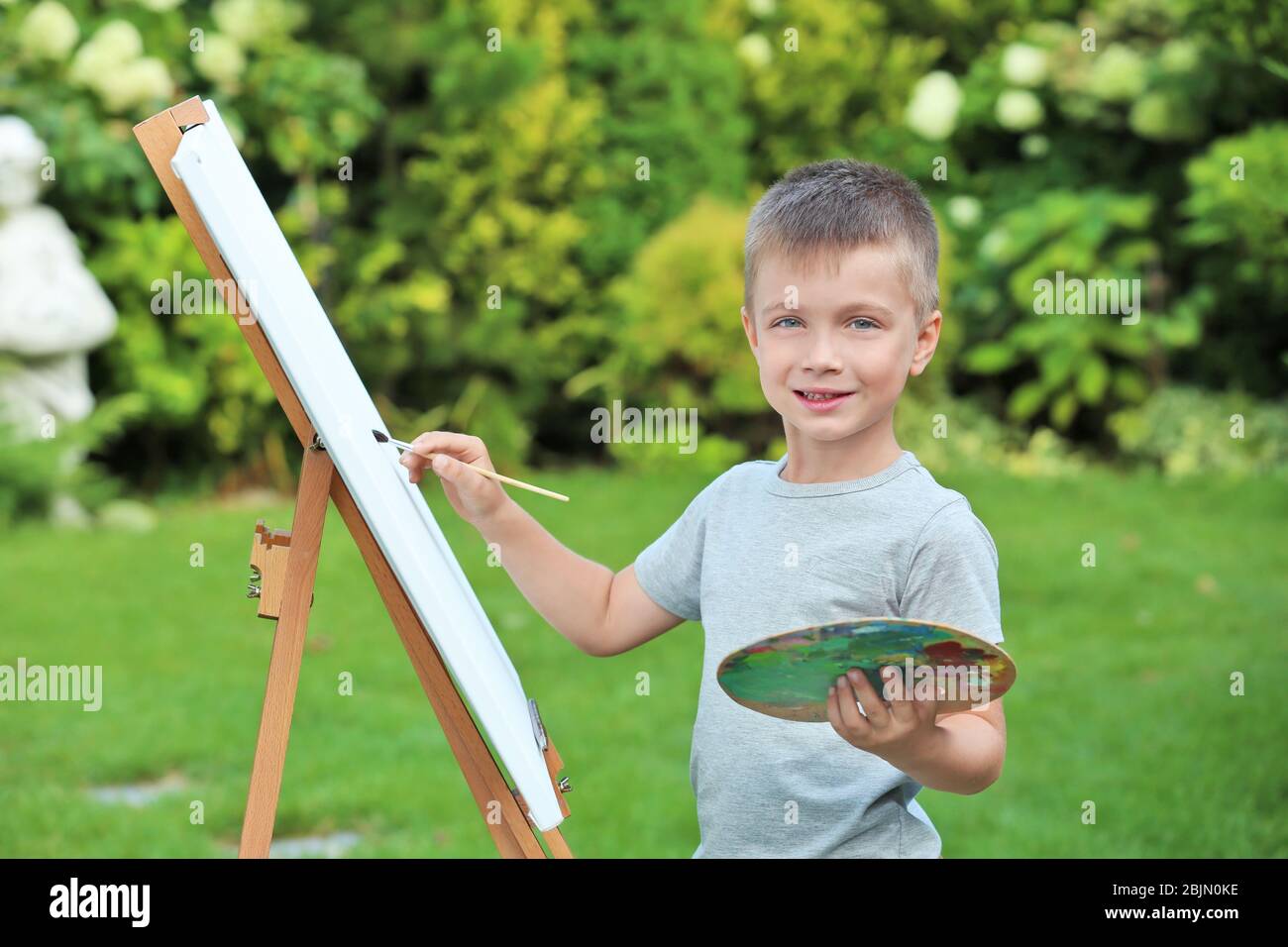 Cute little boy painting picture, outdoors Stock Photo - Alamy