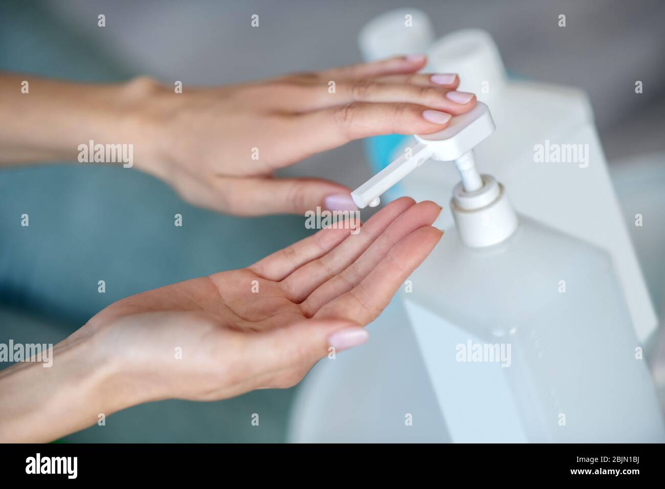 Close up picture of human hands squeezing antiseptic from the bottle ...