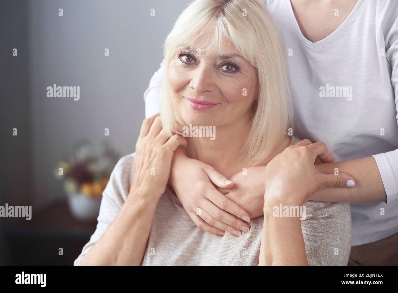 Mature and young women hugging indoors. Elderly care concept Stock ...