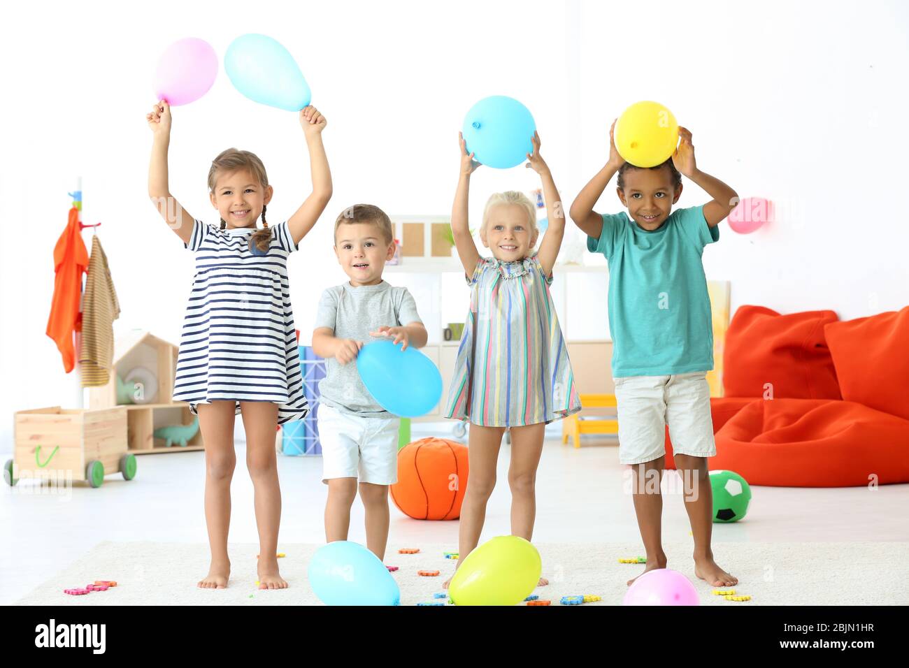 Cute children playing with balloons indoor Stock Photo - Alamy