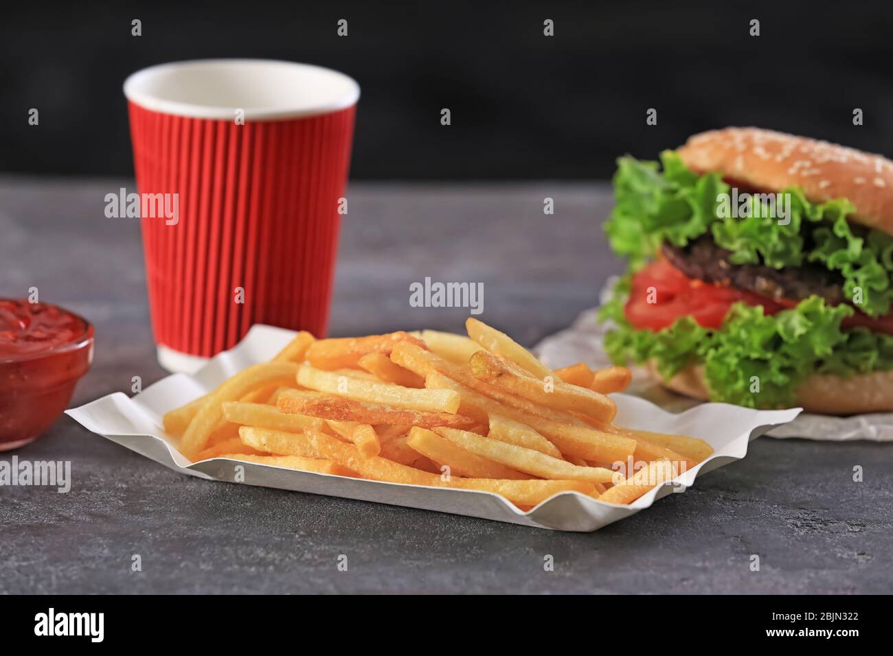 Paper plate with yummy french fries on table Stock Photo - Alamy